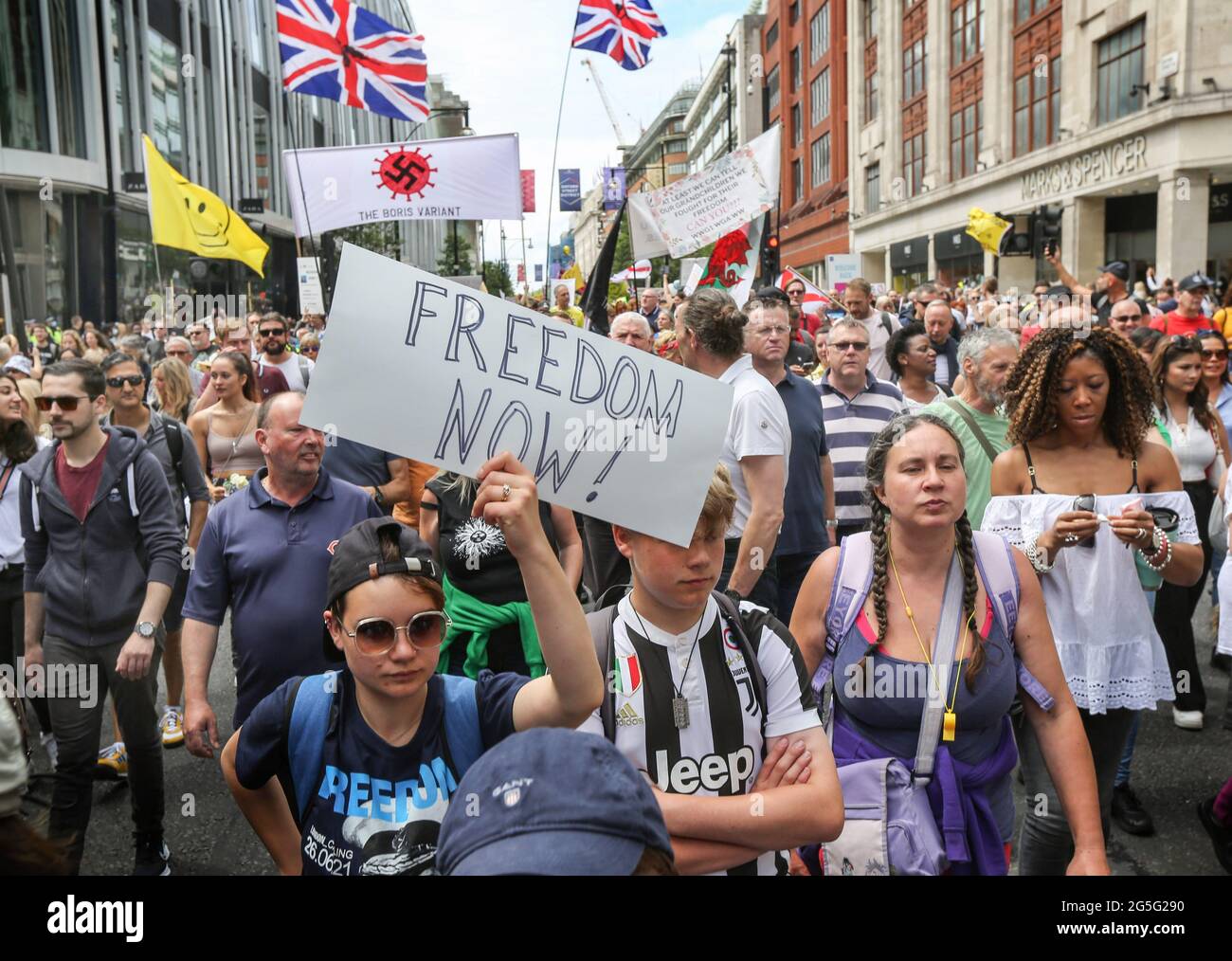 London, UK. 26th June, 2021. A protester holding a placard saying ...