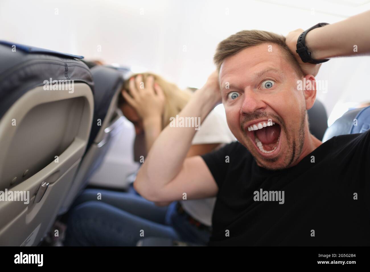 Man flying in airplane and screaming in fear Stock Photo - Alamy