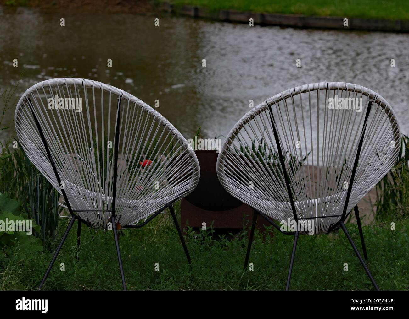 Two modern style chairs seen outside looking over a lake in the UK ...
