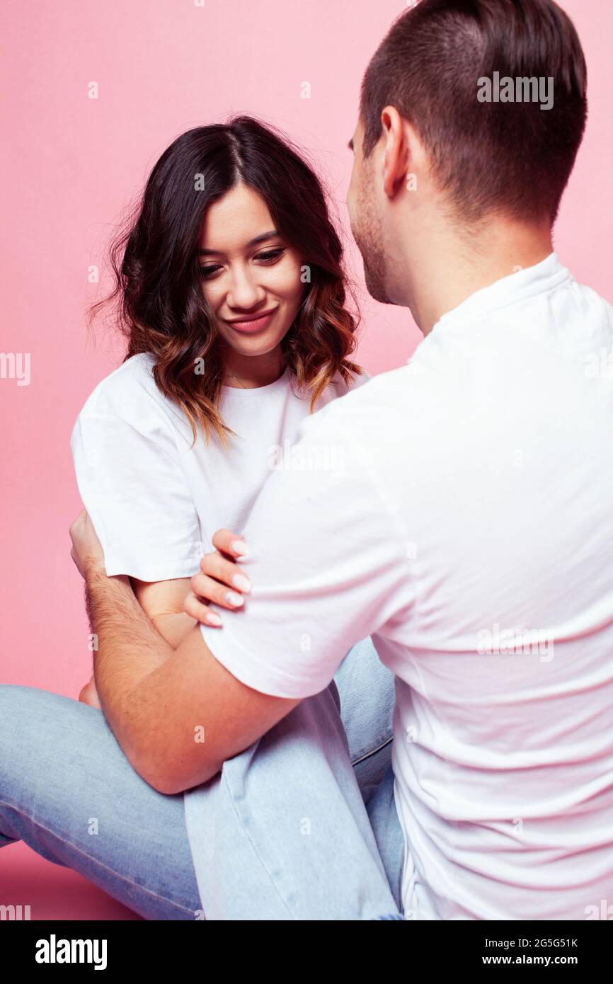 young cheerful caucasian couple together having fun on pink background ...