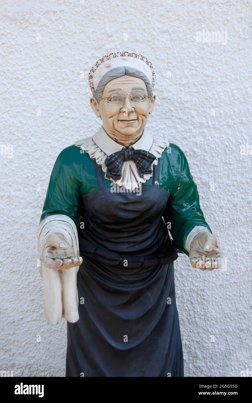 Life-size model of a lady, dressed as a waitress with empty hands but ...