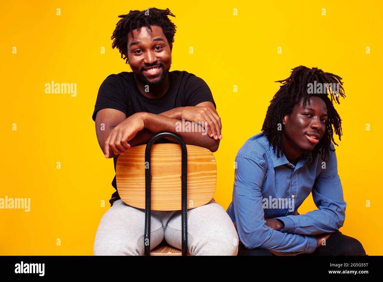 two african american guys posing cheerful together on yellow background ...