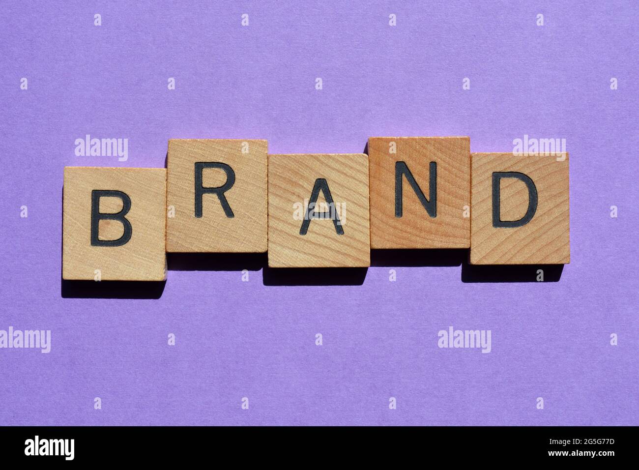 Brand, word in wooden alphabet letters isolated on purple background as ...