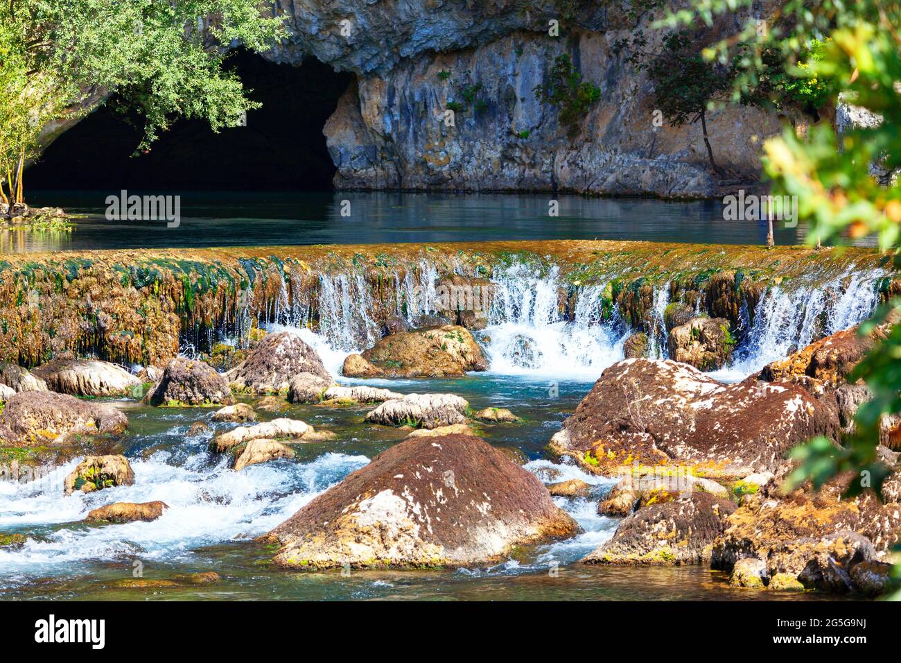 Natural spring flowing from a cavern . Scenic spring with waterfalls ...