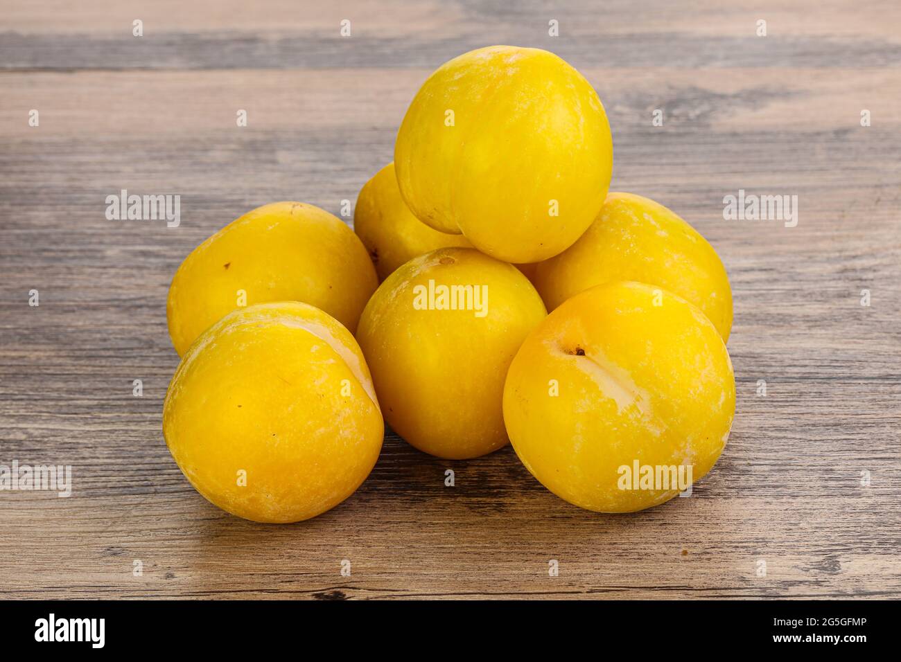 Ripe sweet yellow plum heap over background Stock Photo - Alamy