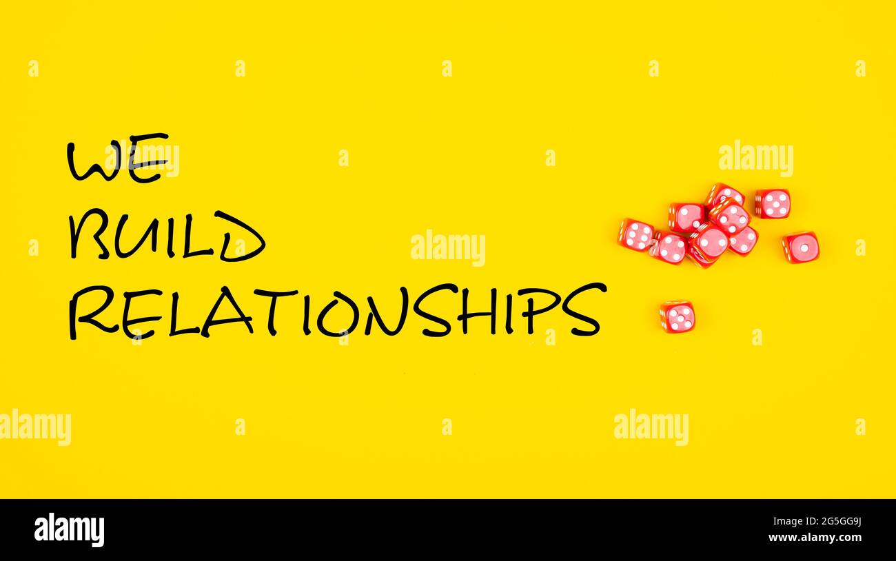 A yellow background with "we build relationships" text and dice Stock ...