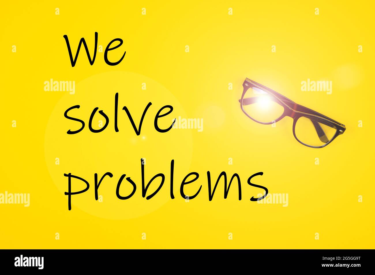 A top view of a yellow background with "we solve problems" text and glasses Stock Photo - Alamy