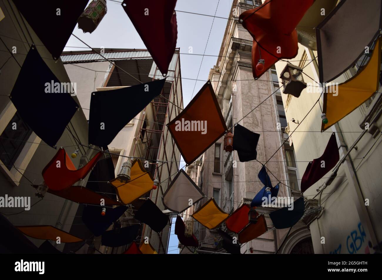 Flags colorful between buildings Stock Photo - Alamy