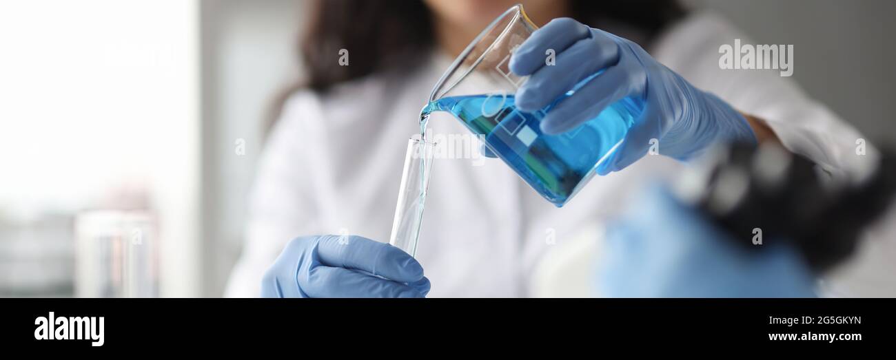 Lab technician with gloves pours chemical into test tube Stock Photo ...