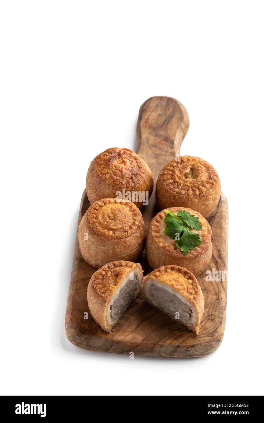 Mini Melton Mowbray pork pies with one halved isolated on white ...