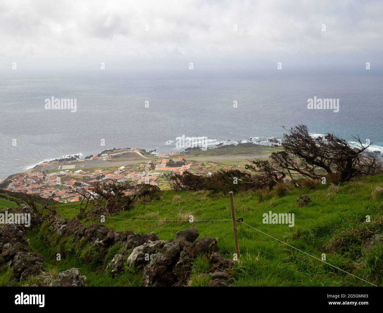 Walking route between the stone walls dividing the green grass fields ...
