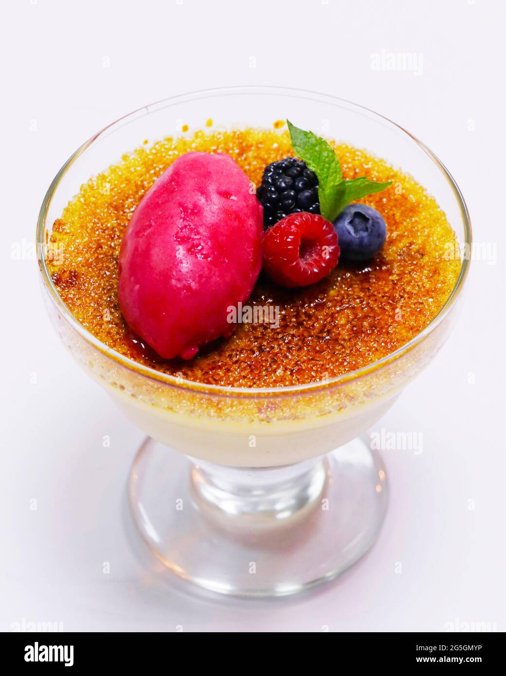 passion creme brulee with raspberry sorbet and berries Stock Photo - Alamy