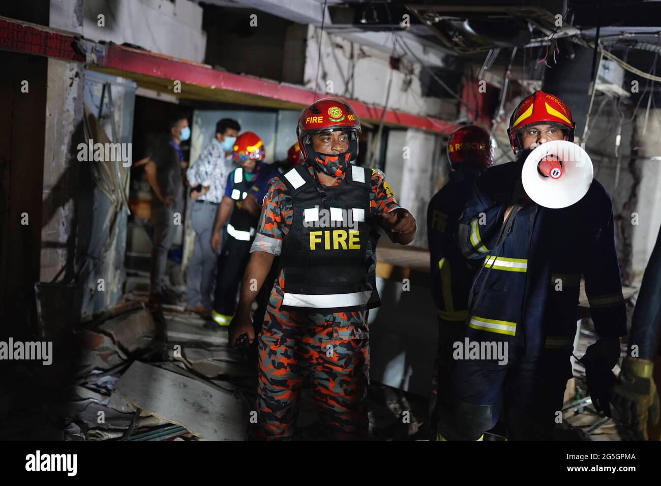 Firefighters inspect the scene after a suspected gas explosion at ...