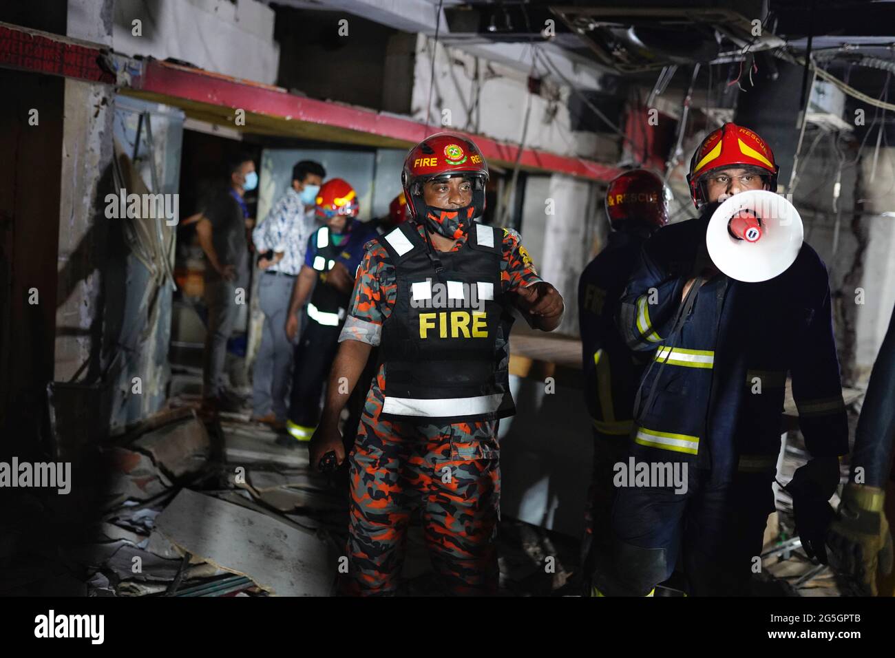 Dhaka, Bangladesh. 27th June, 2021. Firefighters inspect the scene ...