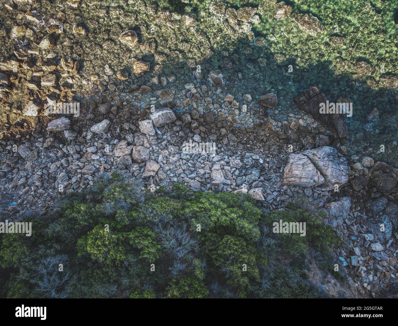 An aerial top view of rocky shore with green vegetation Stock Photo - Alamy