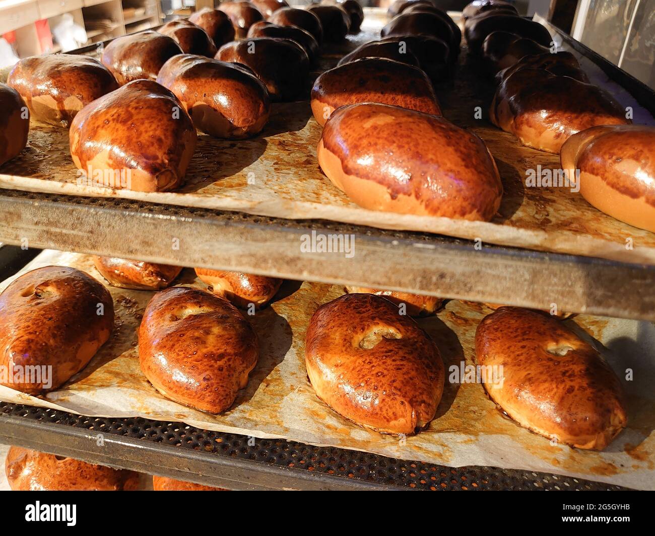 Close-up of many hot delicious pies on shelves in bakery, store ...