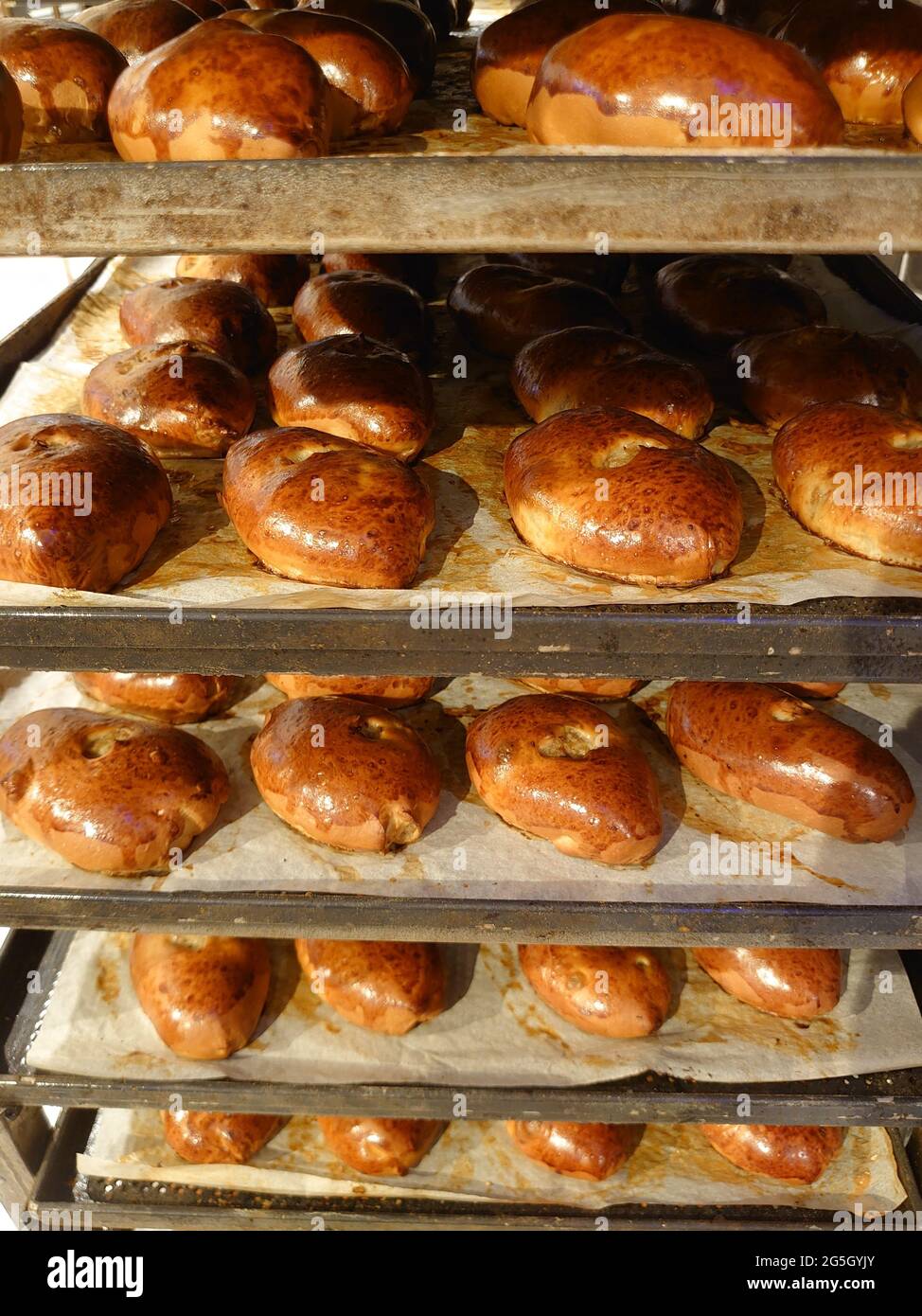 Close-up of many hot delicious pies on shelves in bakery, store ...