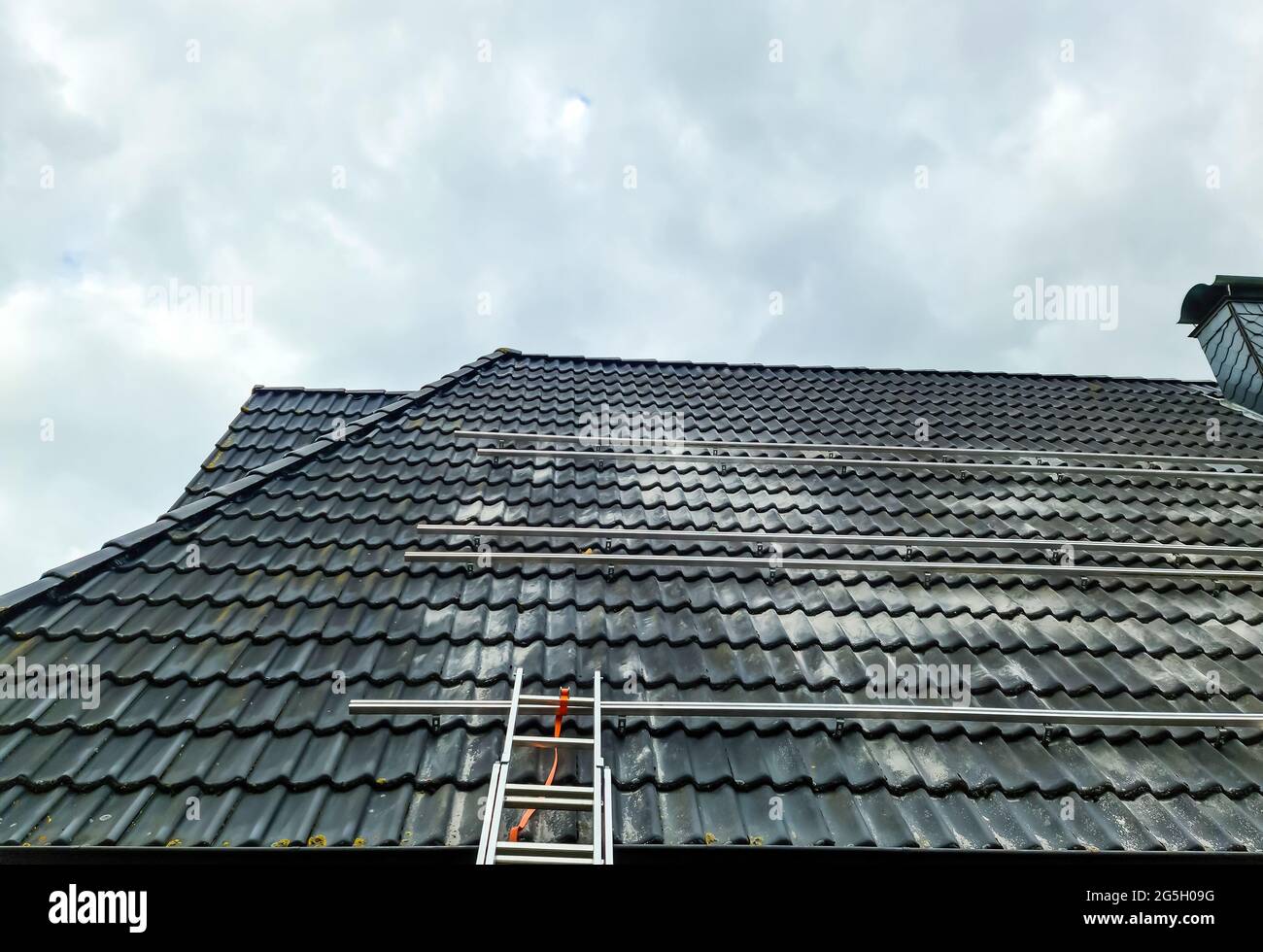 View at the roof tiles and a ladder of a residential house during roof ...