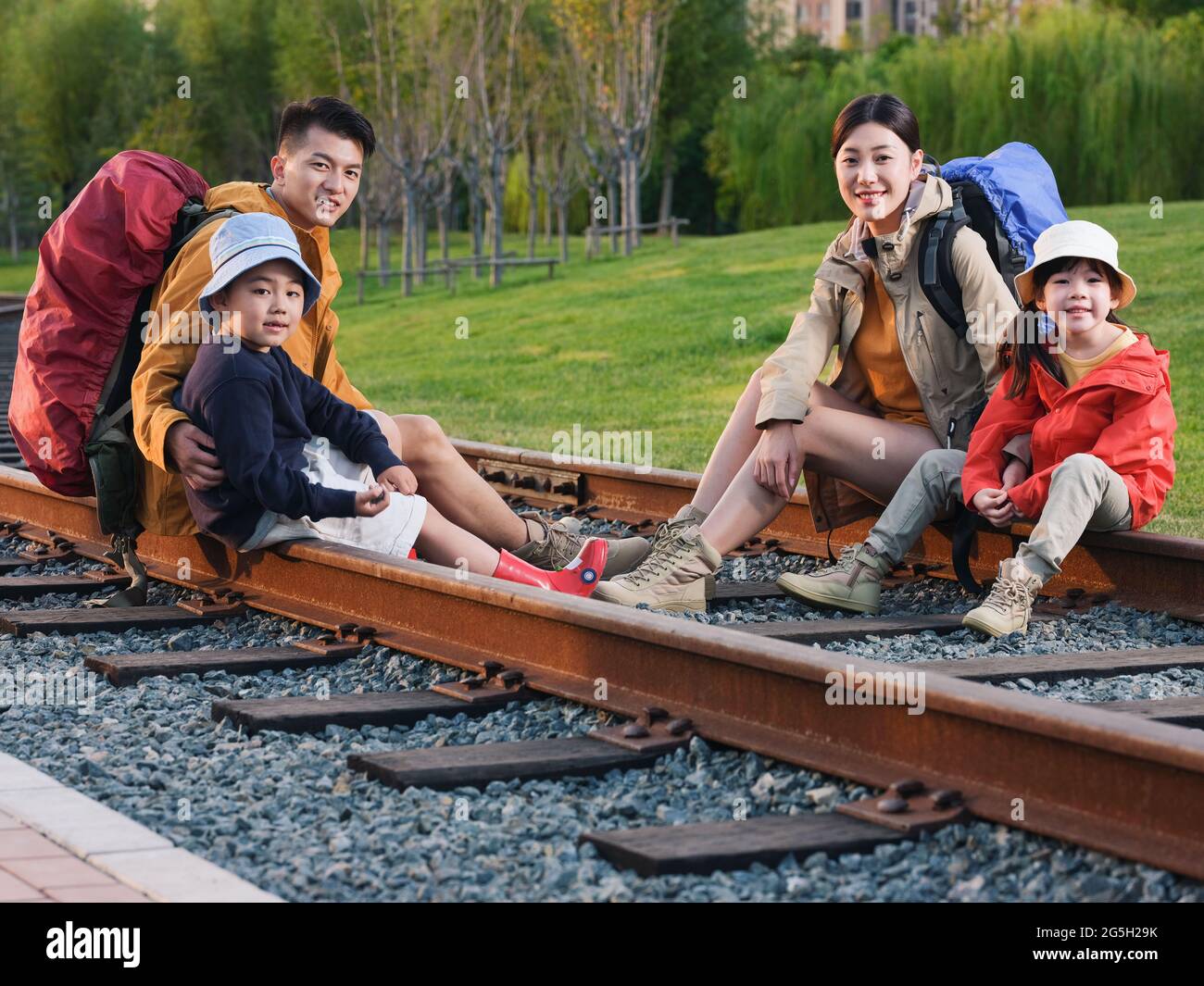 Happy family of four sitting on the track to rest high quality photo ...