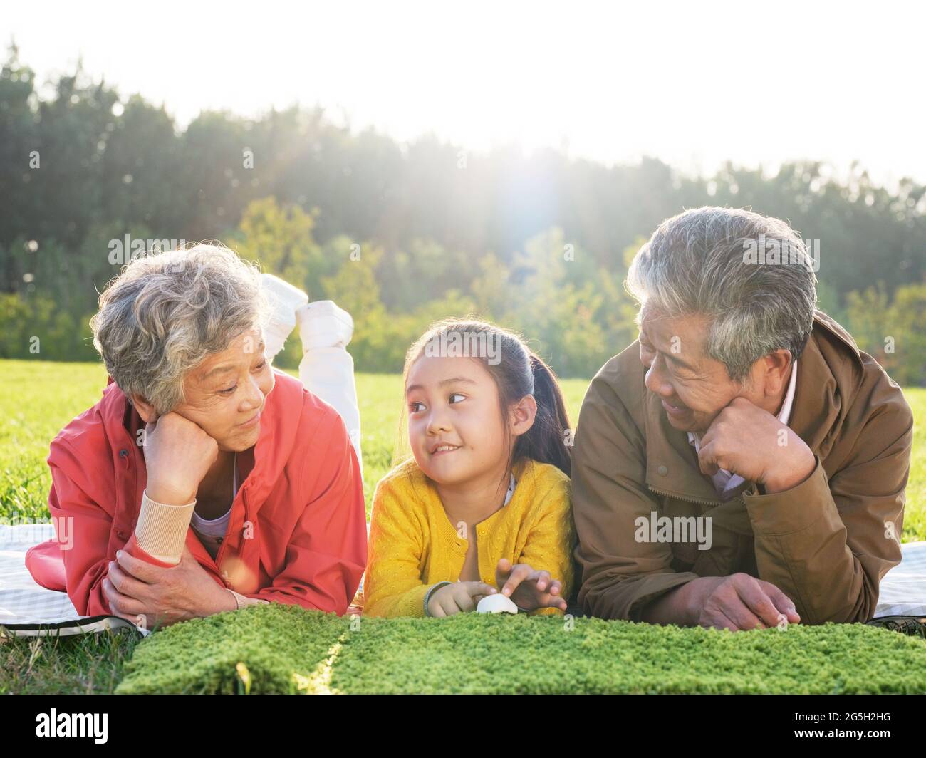 Happy grandparents and grandchildren take a group photo in the park ...