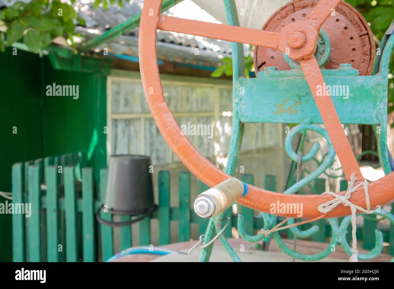 An old water well with a bucket in the garden, a metal handle for ...
