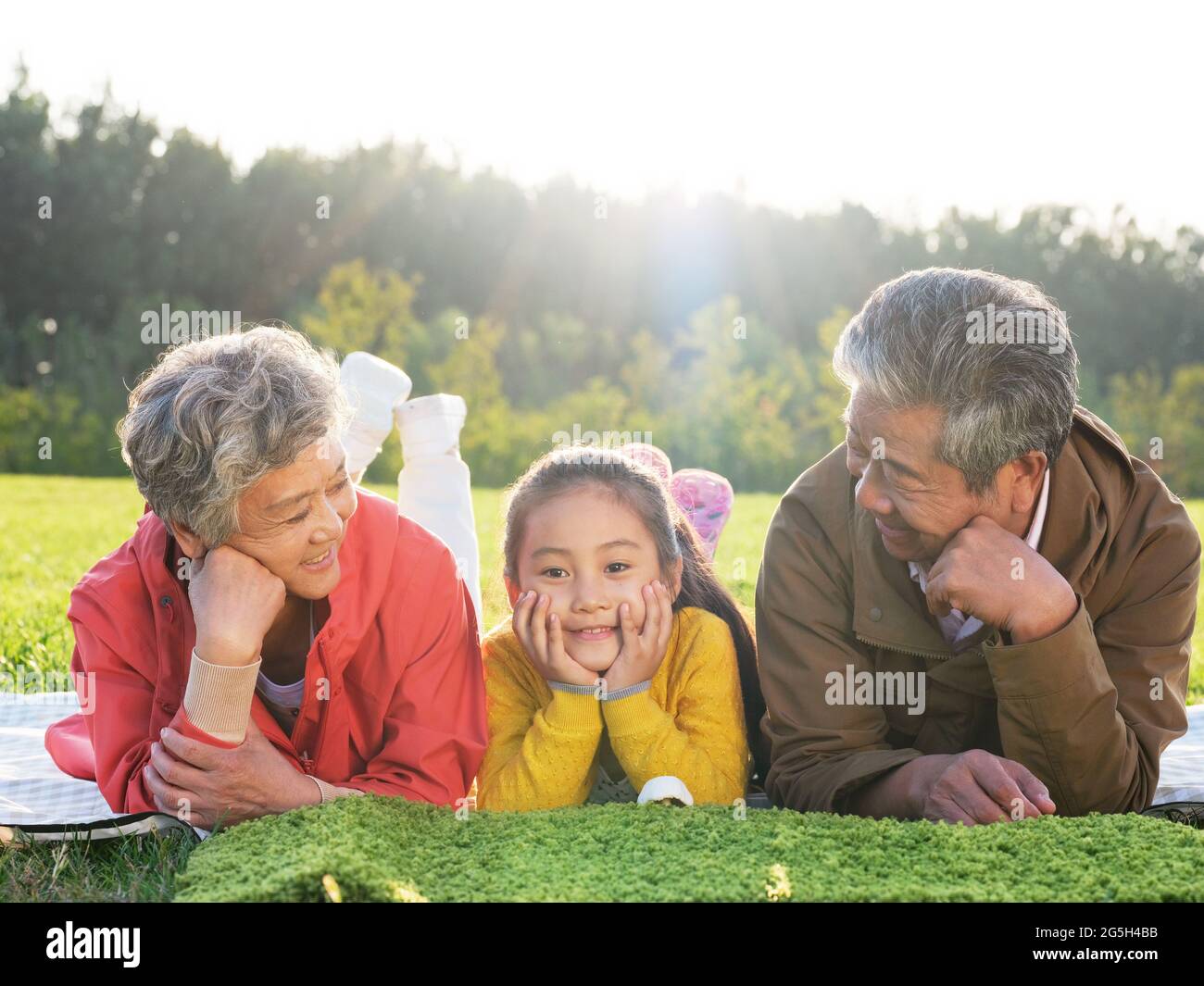 Happy grandparents and grandchildren take a group photo in the park ...