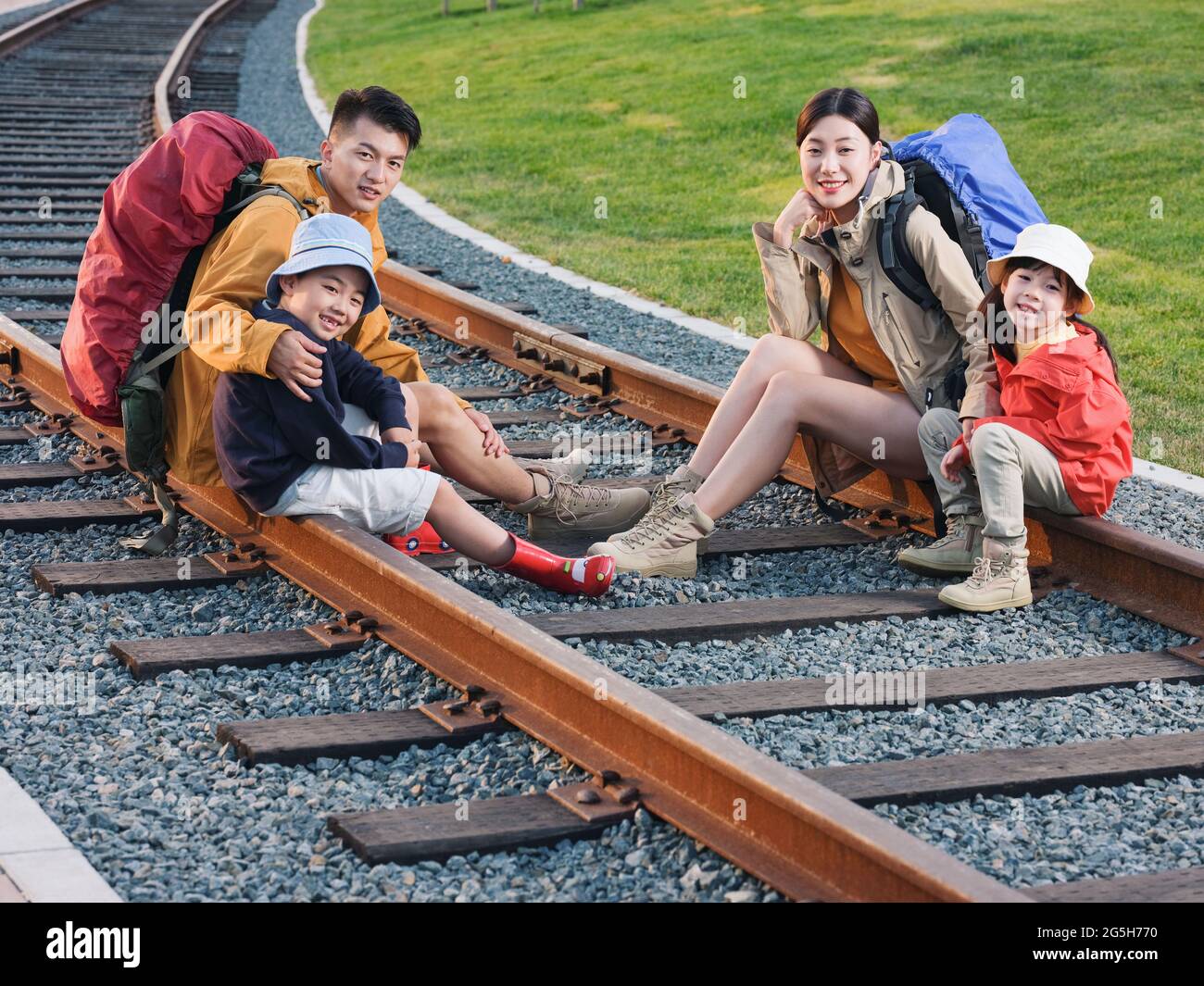 Happy family of four sitting on the track to rest high quality photo ...