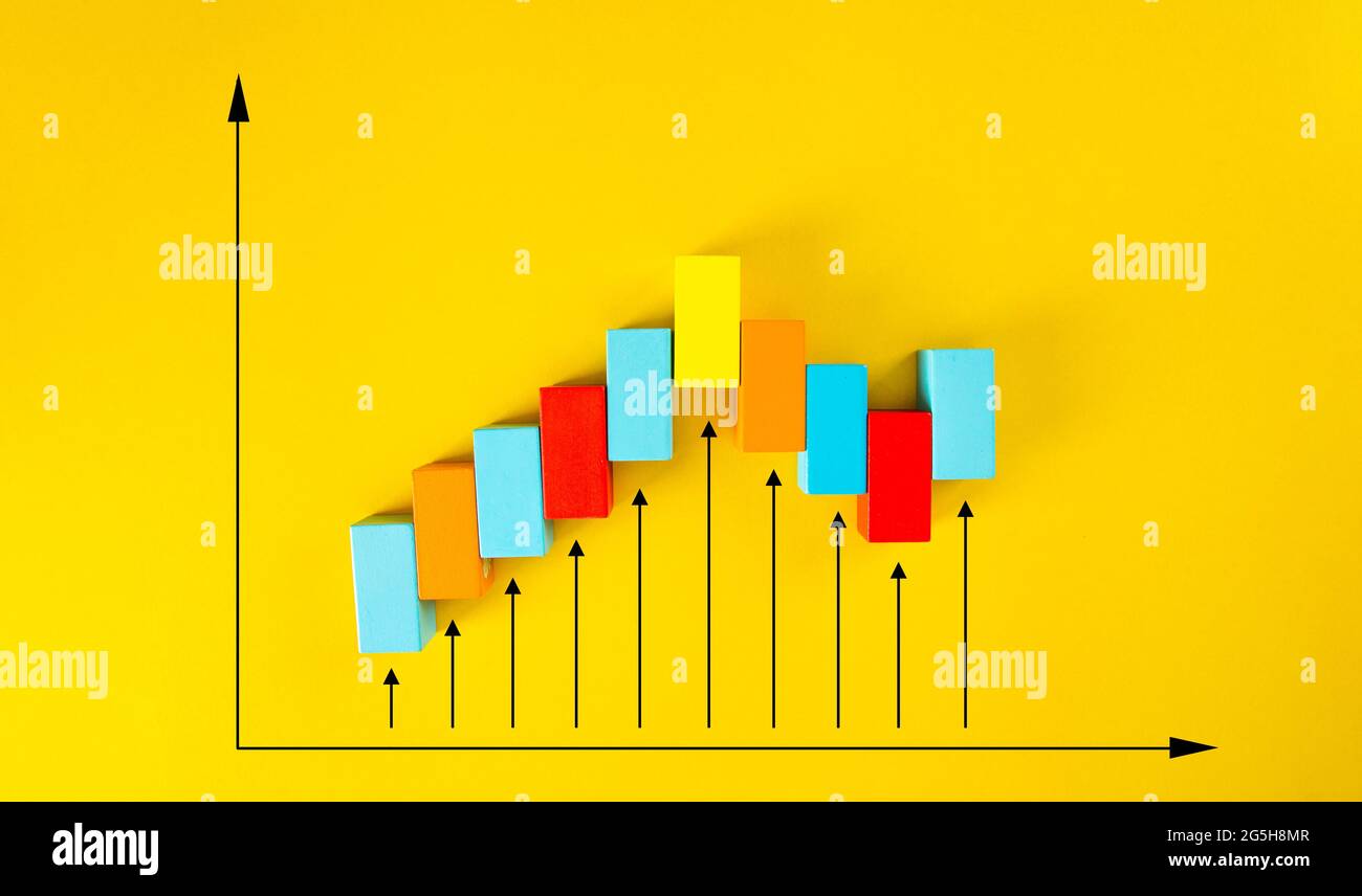 Wooden blocks arranged in an increasing graph on yellow background ...