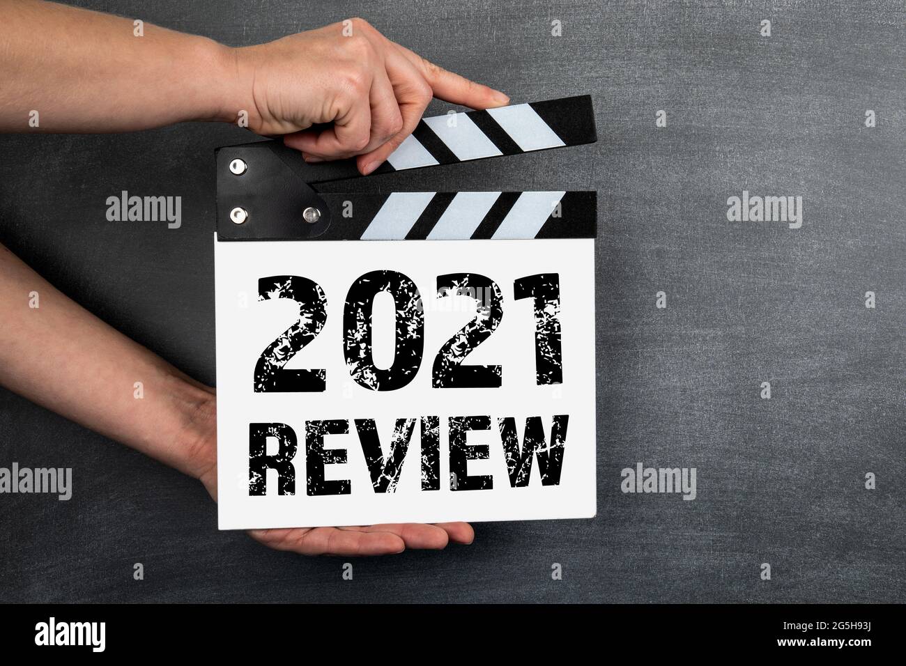 2021 Review concept. White movie clapper on a background of a dark ...