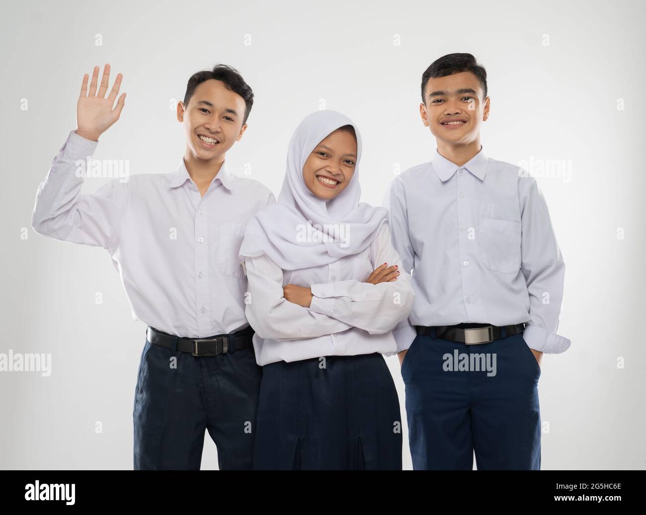 Three teenagers in junior high school uniforms smiling with say hello ...