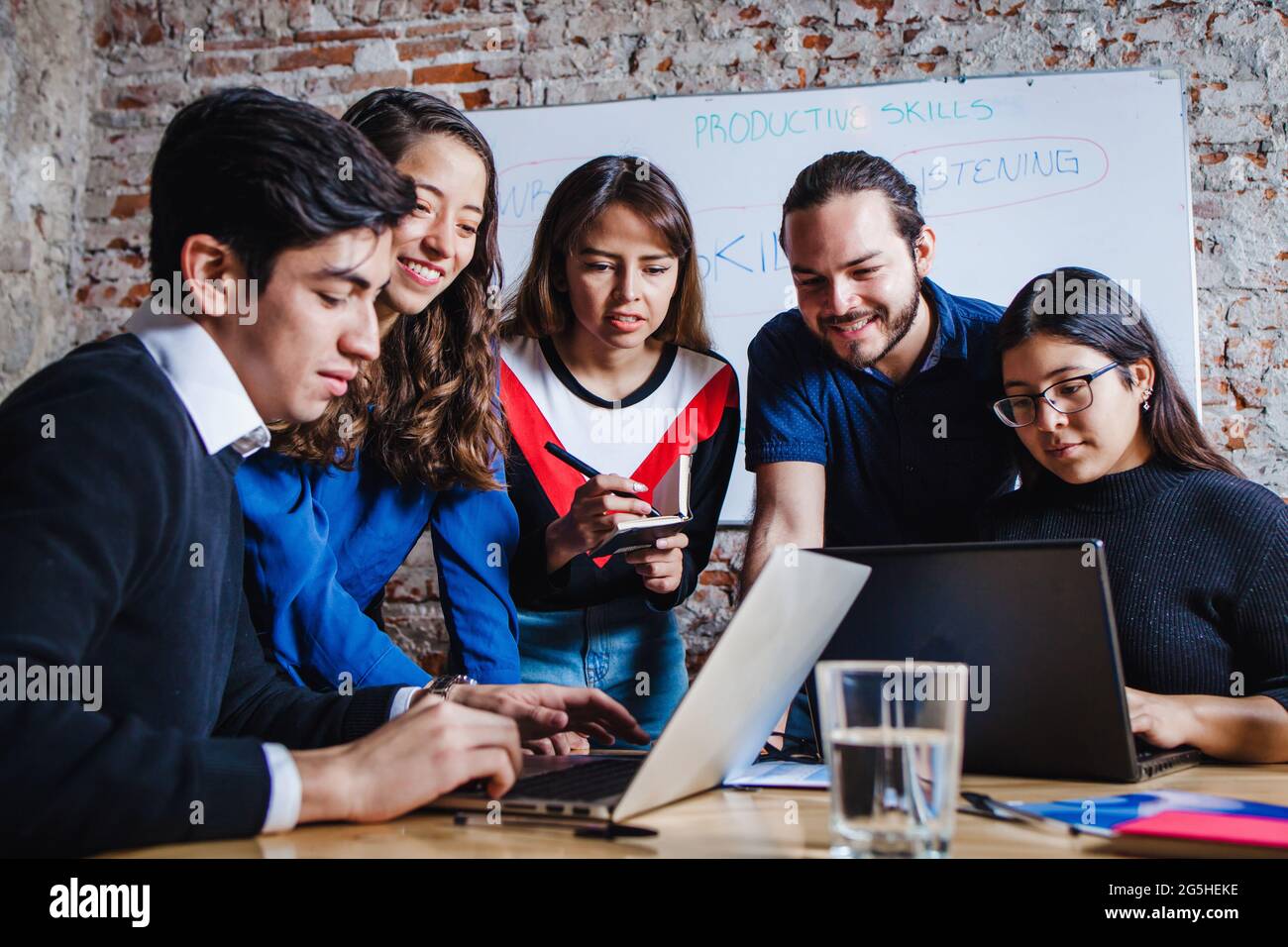 Group of young latin business people working with computer while ...