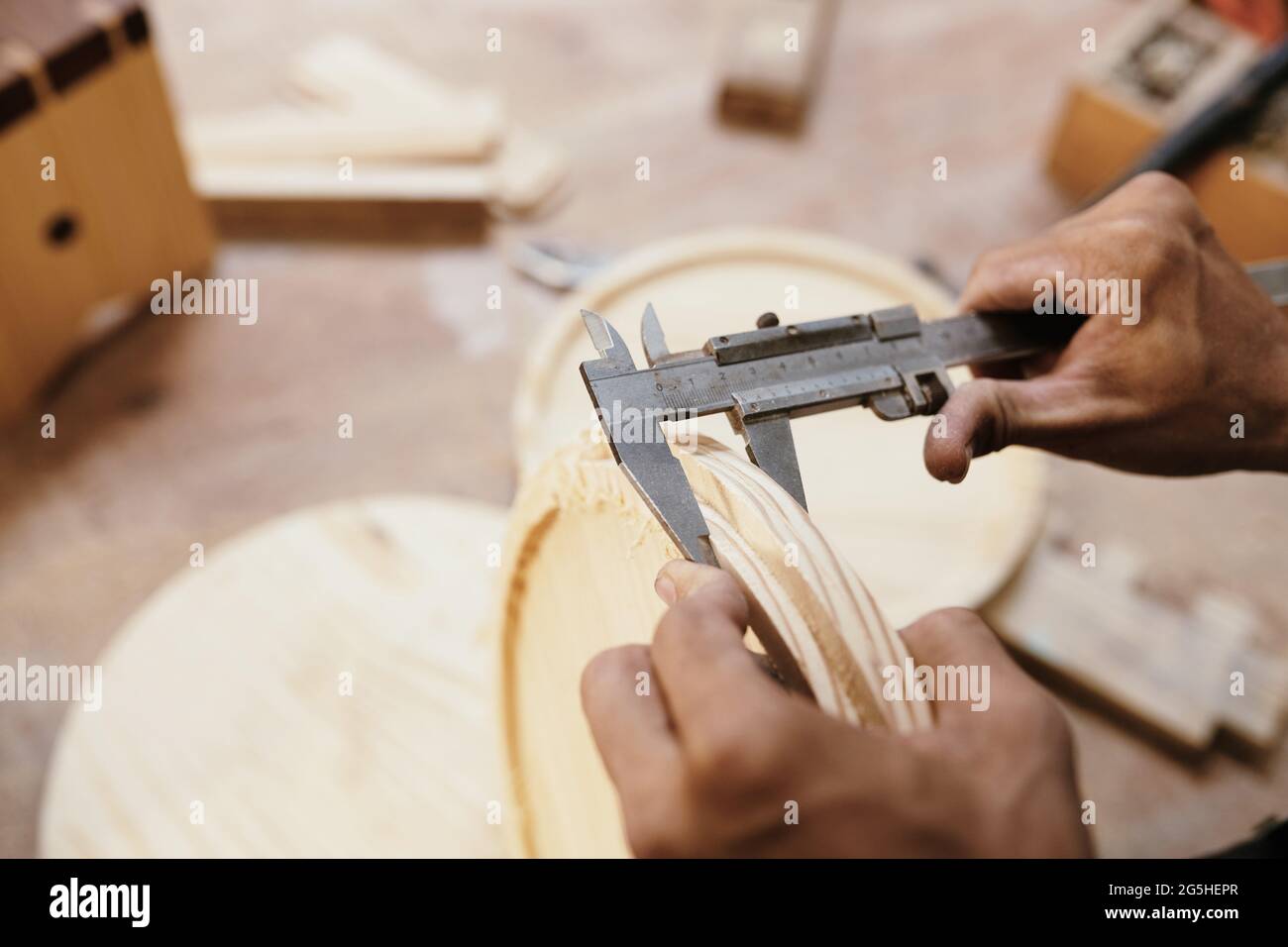 Hands of carpenter using mechanical vernier caliper when measuring ...