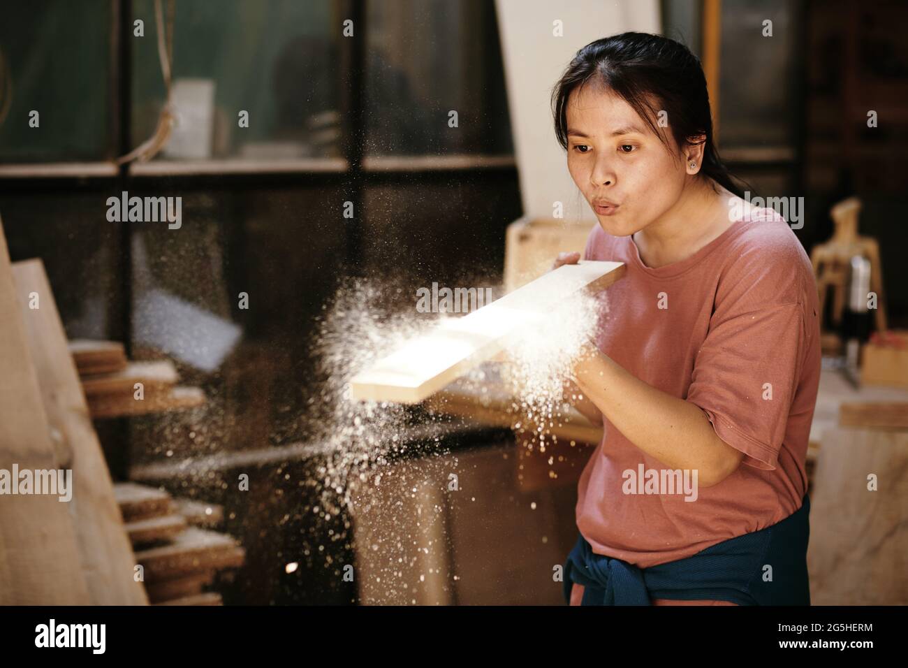 Female carpenter blowing sawdust hi-res stock photography and images ...