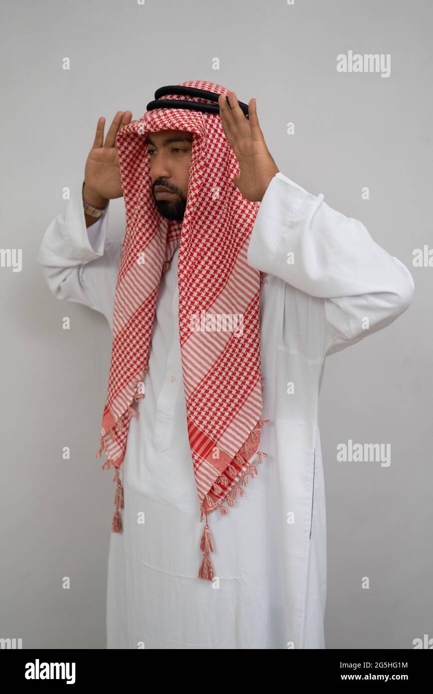 Arab people in turban praying during i'tidal with two hands beside head ...