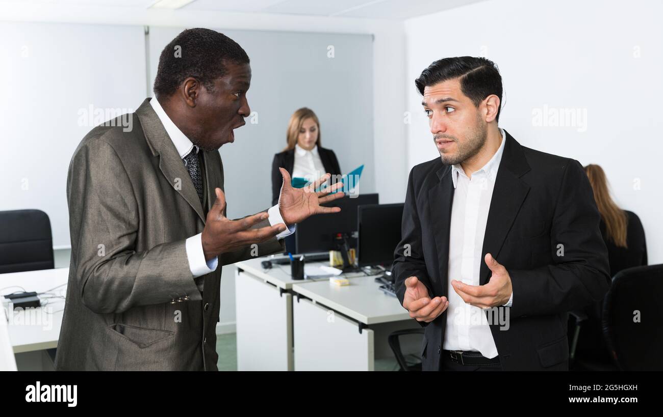 Outraged businessman scolding frustrated man Stock Photo - Alamy