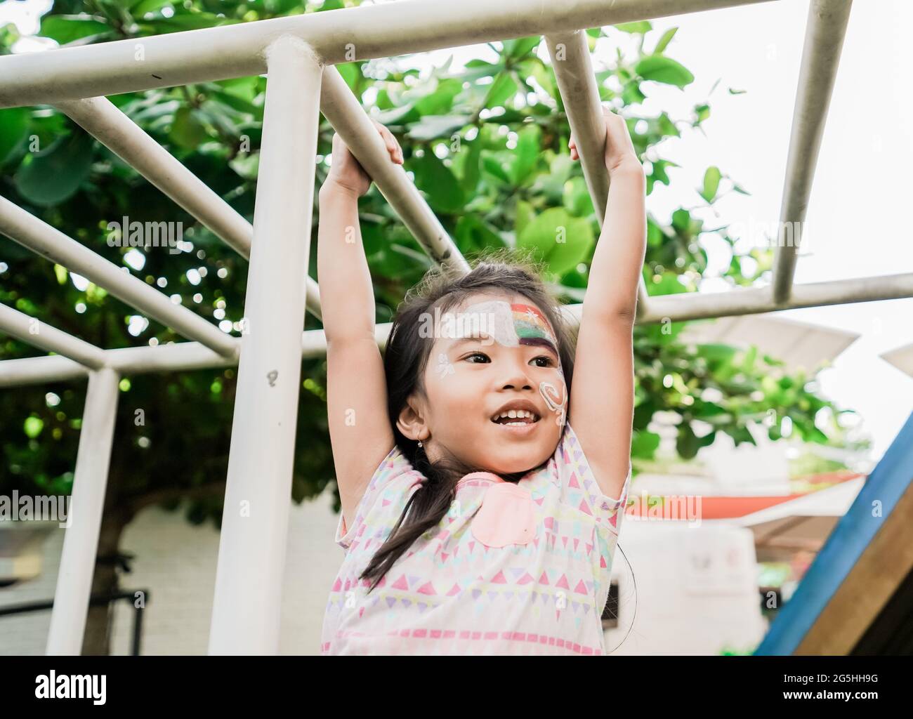 healthy girl hanging on a bar in the playground Stock Photo - Alamy