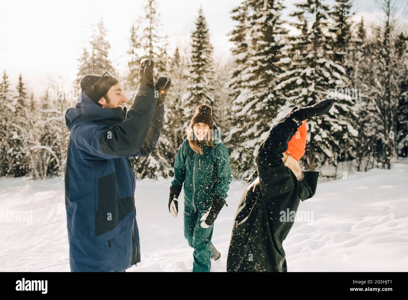 Cheerful man and woman giving high-five by female friend while playing ...