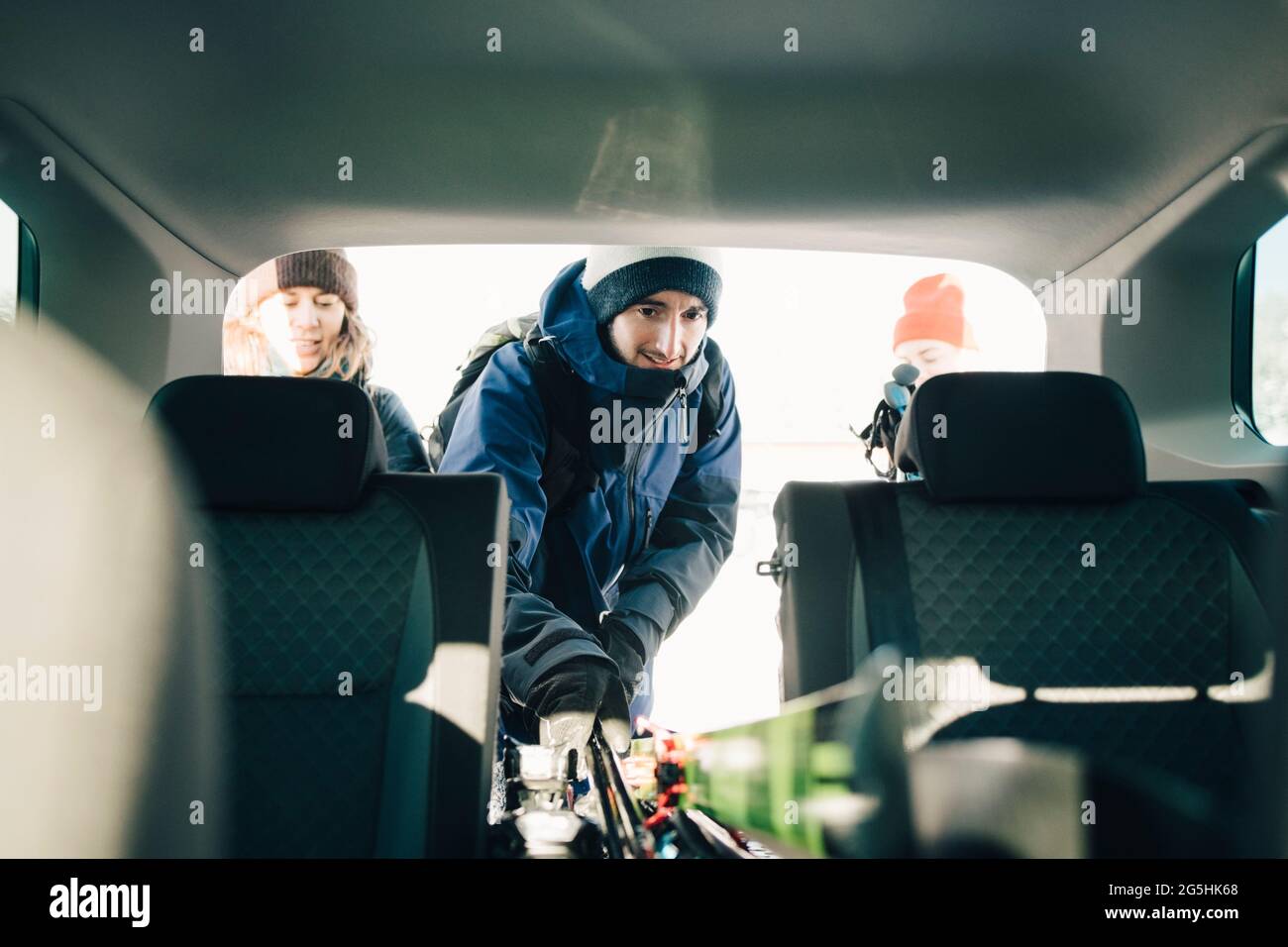 Man loading skis in car trunk during holiday Stock Photo - Alamy