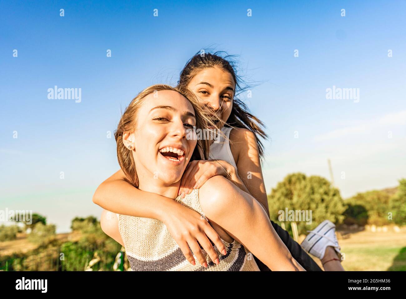 Two girls best friends having fun outdoor in a green nature park ...