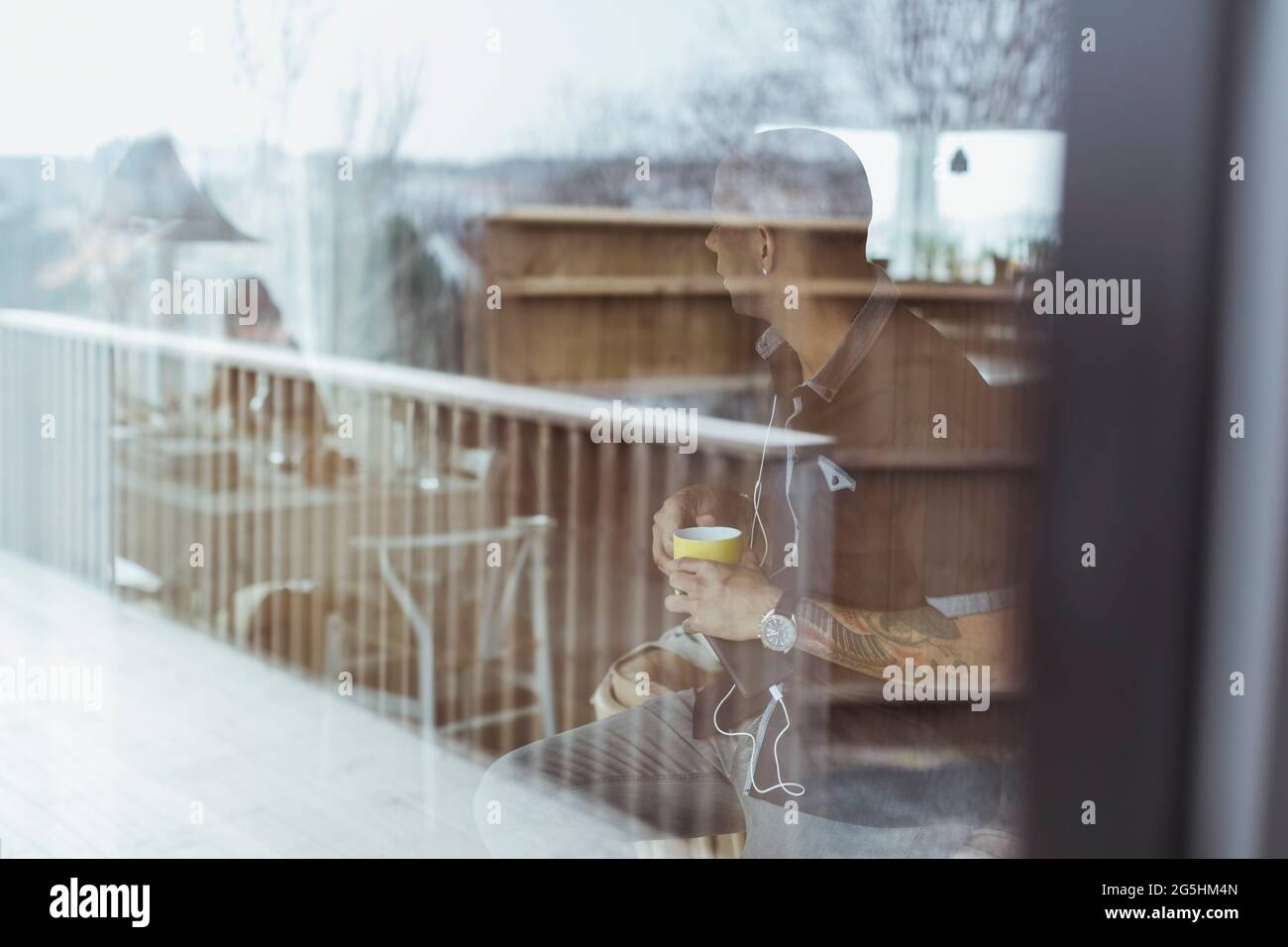 Hispanic man seen through glass window Stock Photo - Alamy