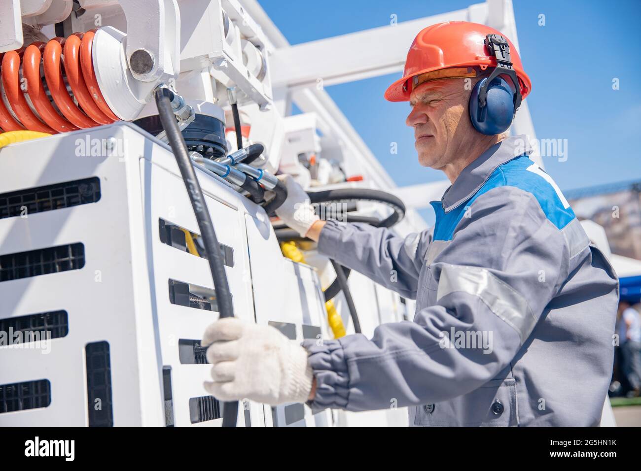 Miner operator in helmet control drilling machine in coal mine. Concept ...
