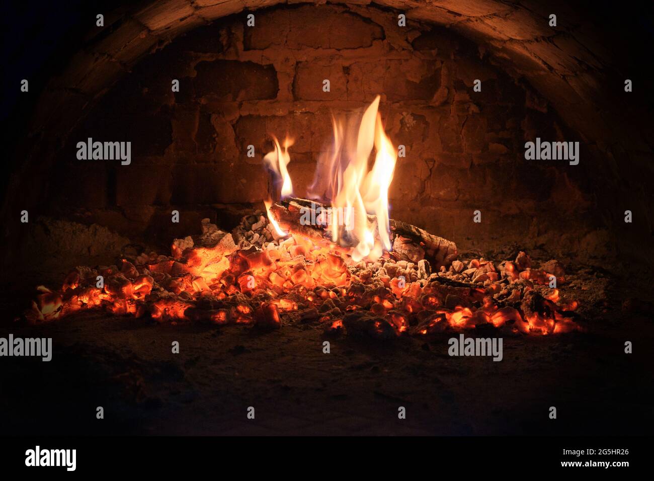 Logs of firewood burn out in the oven. Coals and flames in the ...