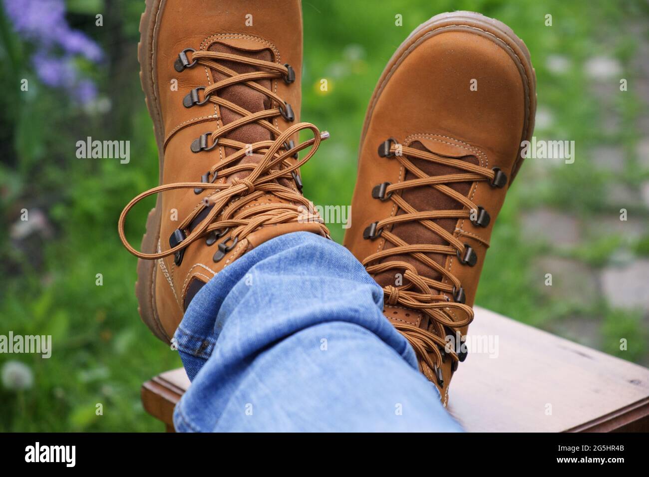 Brown boots and jeans on the legs. Legs are crossed on the stool Stock ...