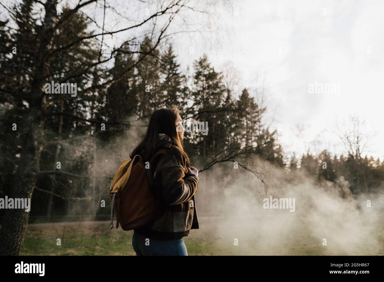 Young female explorer with backpack hiking in forest Stock Photo - Alamy