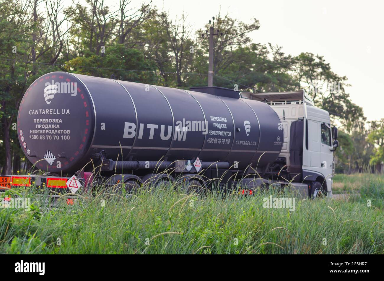 Bitumen tank trailer rides along the road against the backdrop of the ...