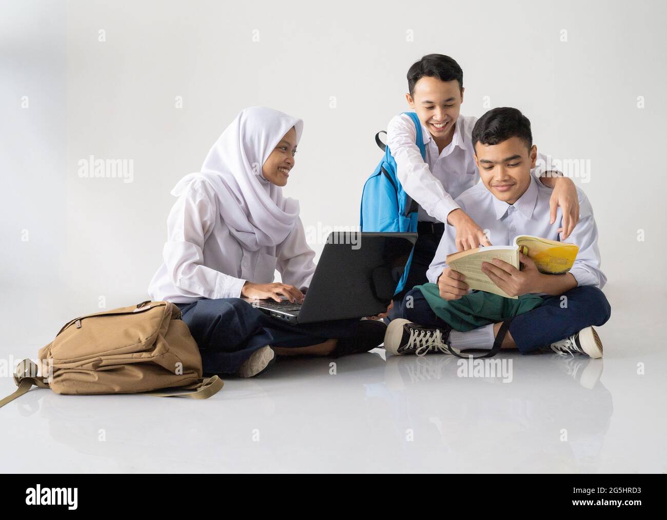 smiling three teenagers in junior high school uniforms sitting on the ...