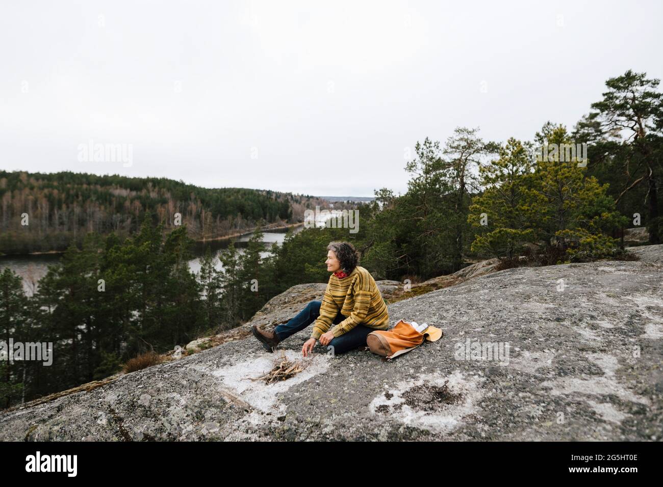 Female hiker sitting by twigs on mountain during vacation Stock Photo ...