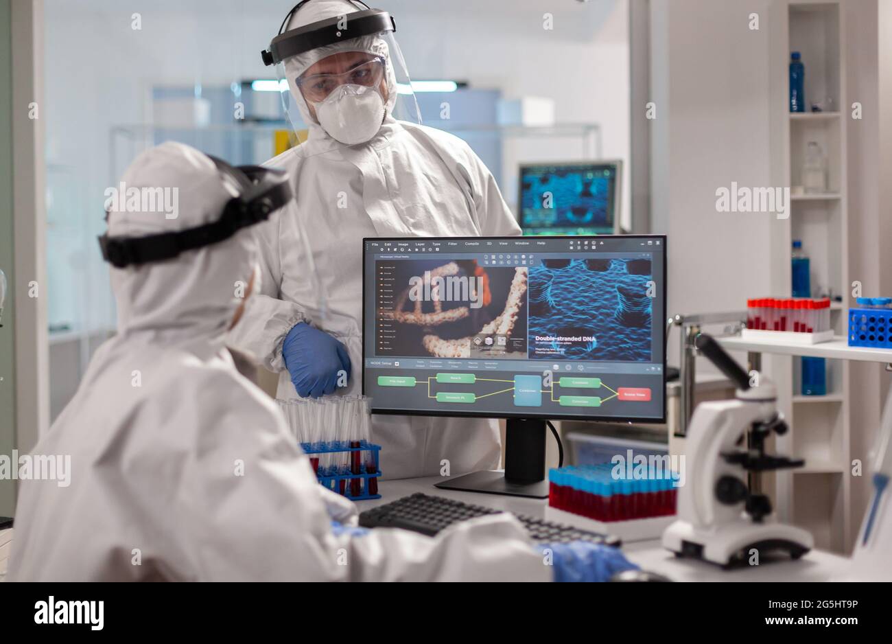 Scientist Team In Prorection Suit Discussing Treatment In Front Of Pc