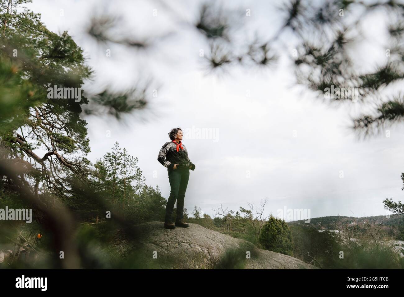 Female explorer standing on rock in forest Stock Photo - Alamy