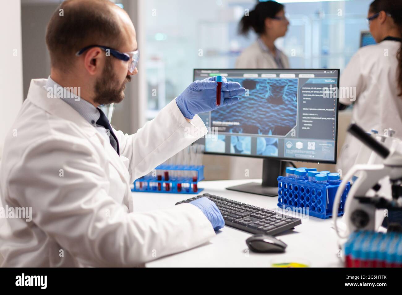 Scientist doing clinic experiment holding blood sample of sick patient ...